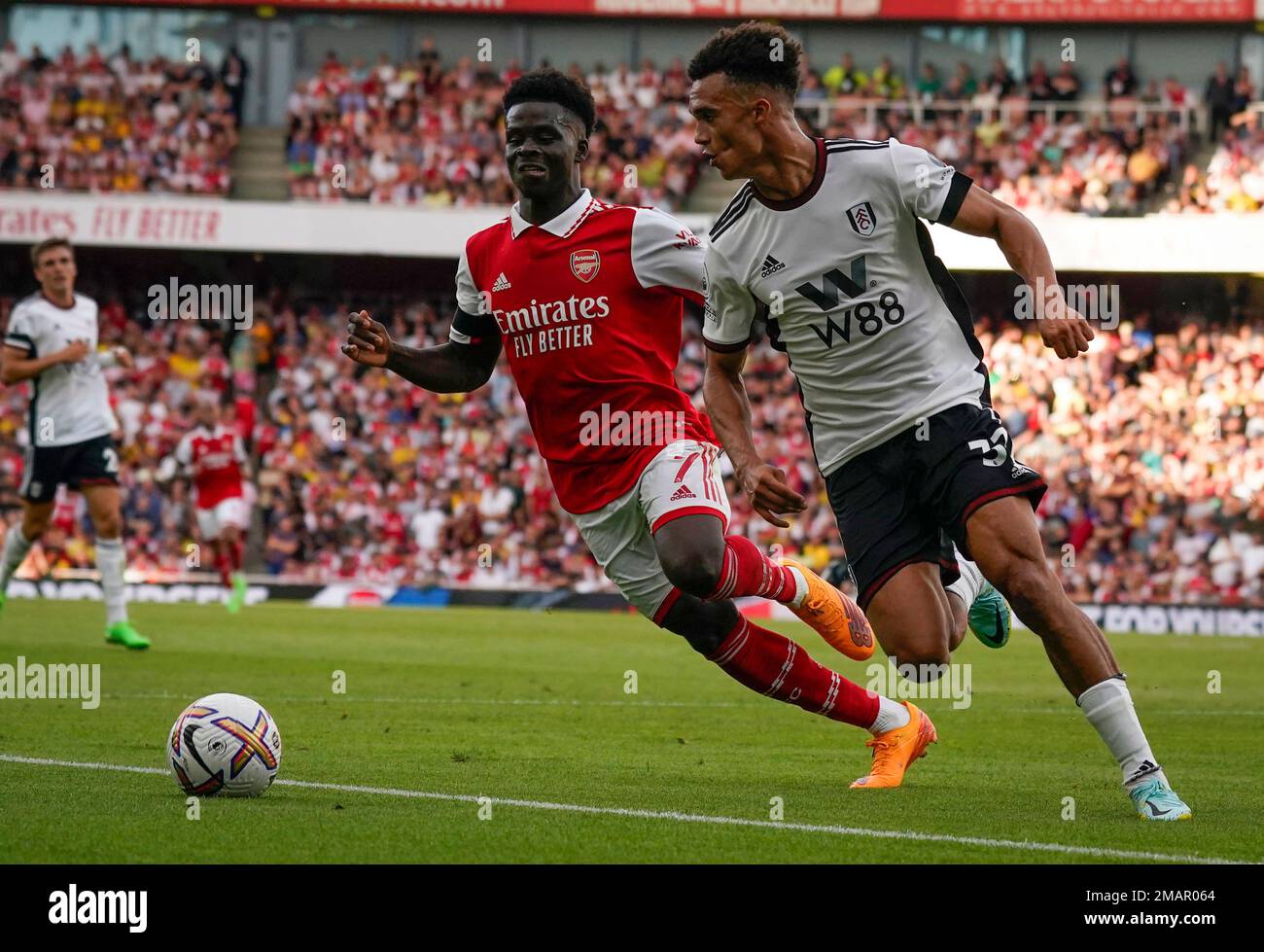 Arsenal's Bukayo Saka, left, challenges for the ball with Fulham's Antonee Robinson during the ...