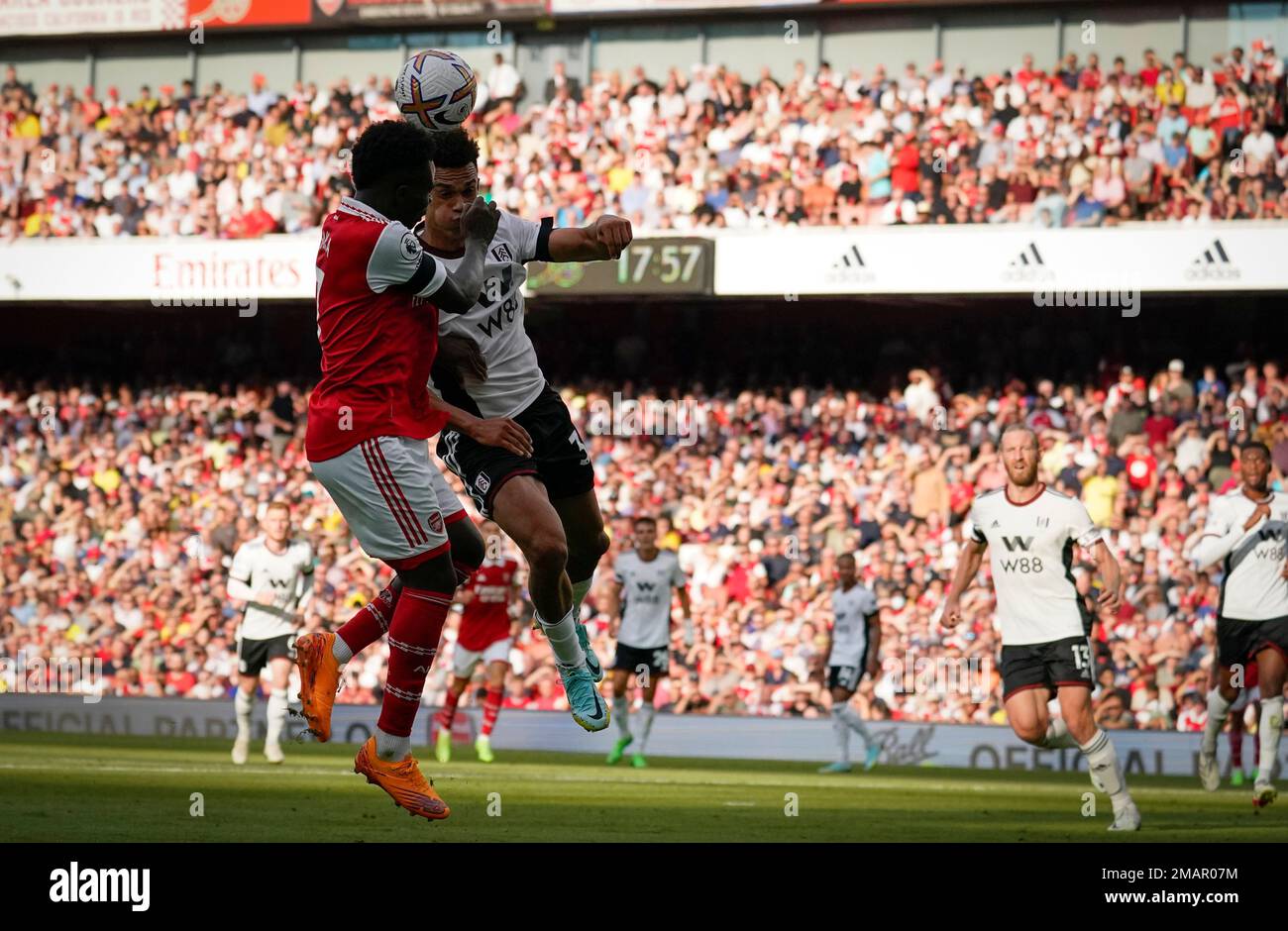 Arsenal's Bukayo Saka, left, challenges for the ball with Fulham's Antonee Robinson during the ...