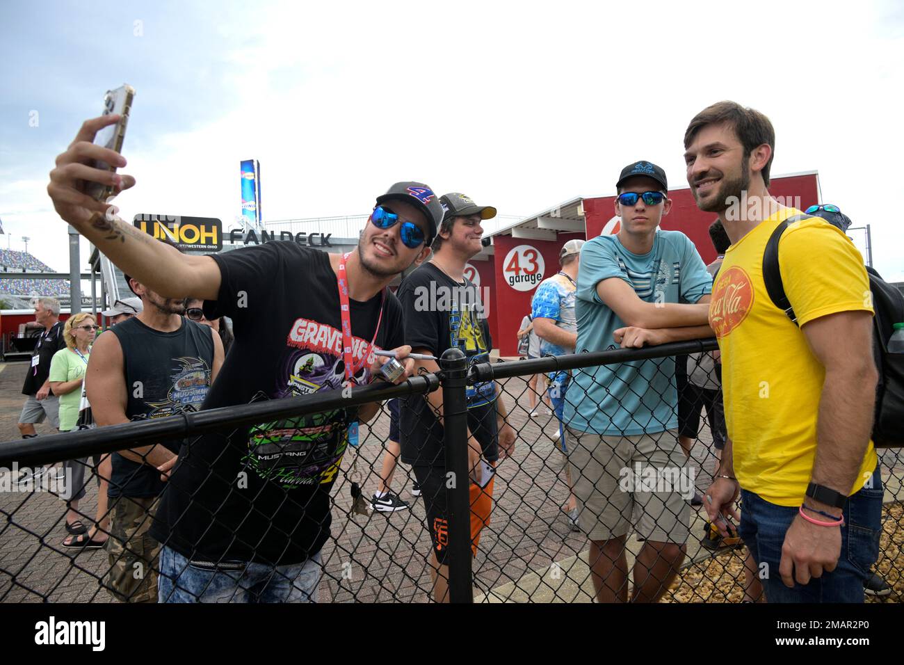 Daniel Suarez, right, poses for a photo with fans in the infield before ...