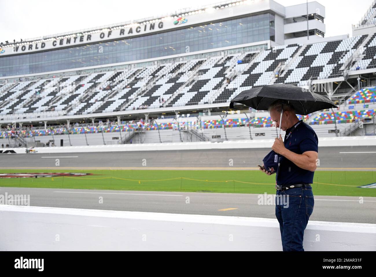 John Dunkin keeps dry on pit road as rain fall before a NASCAR Xfinity ...
