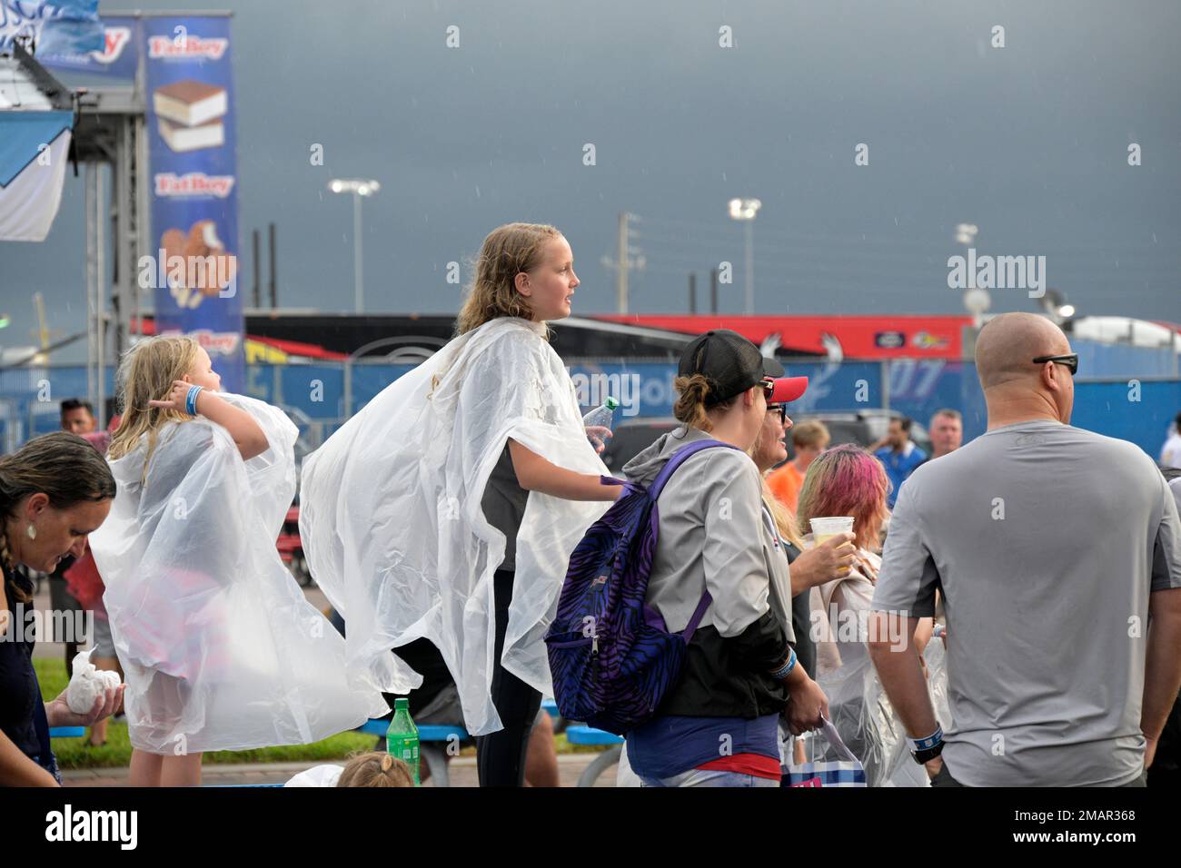Spectators stand in the infield area as a storm approaches before a ...
