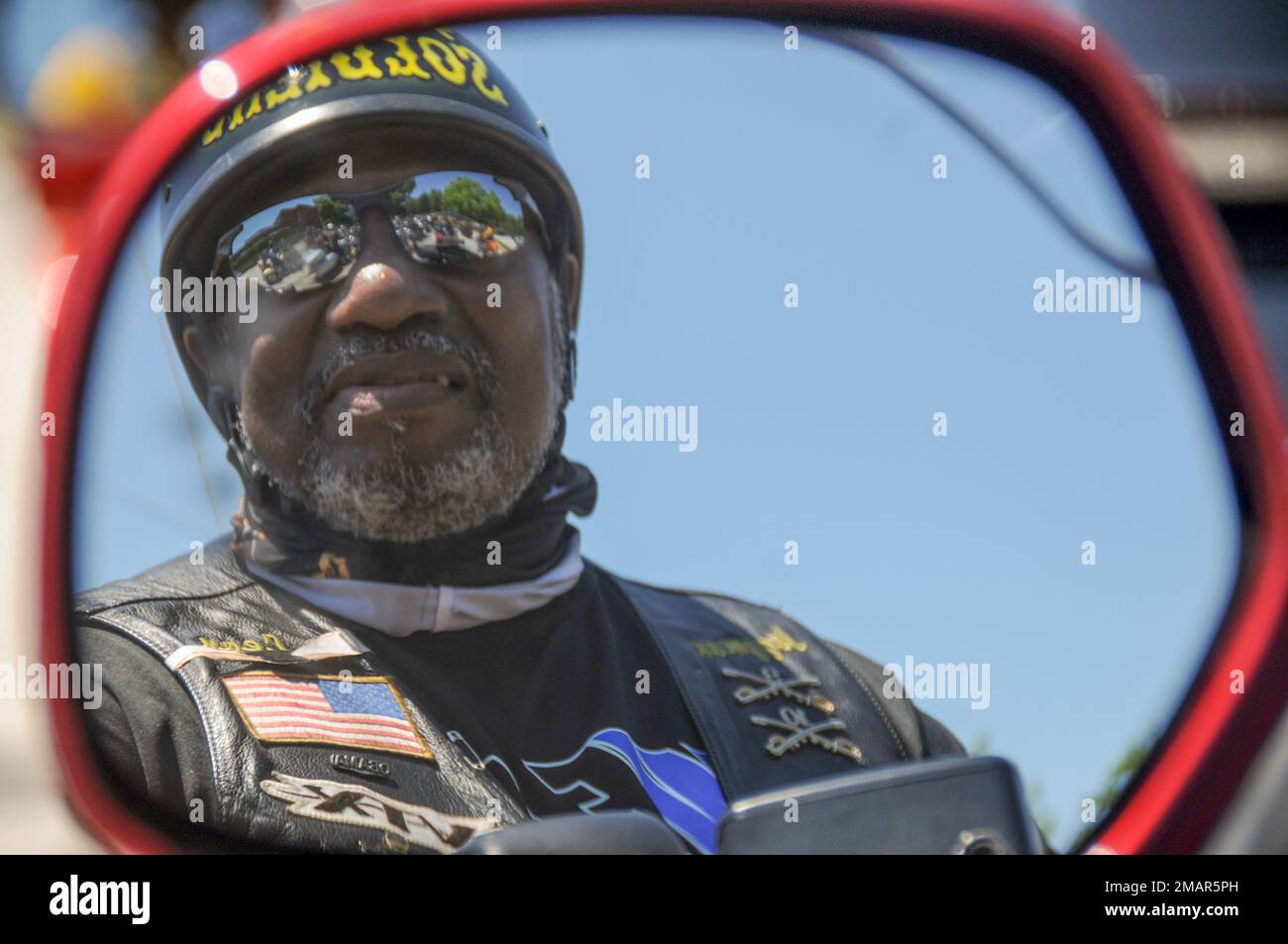 A member of the Buffalo Soldiers Motorcycle club is seen reflected in ...