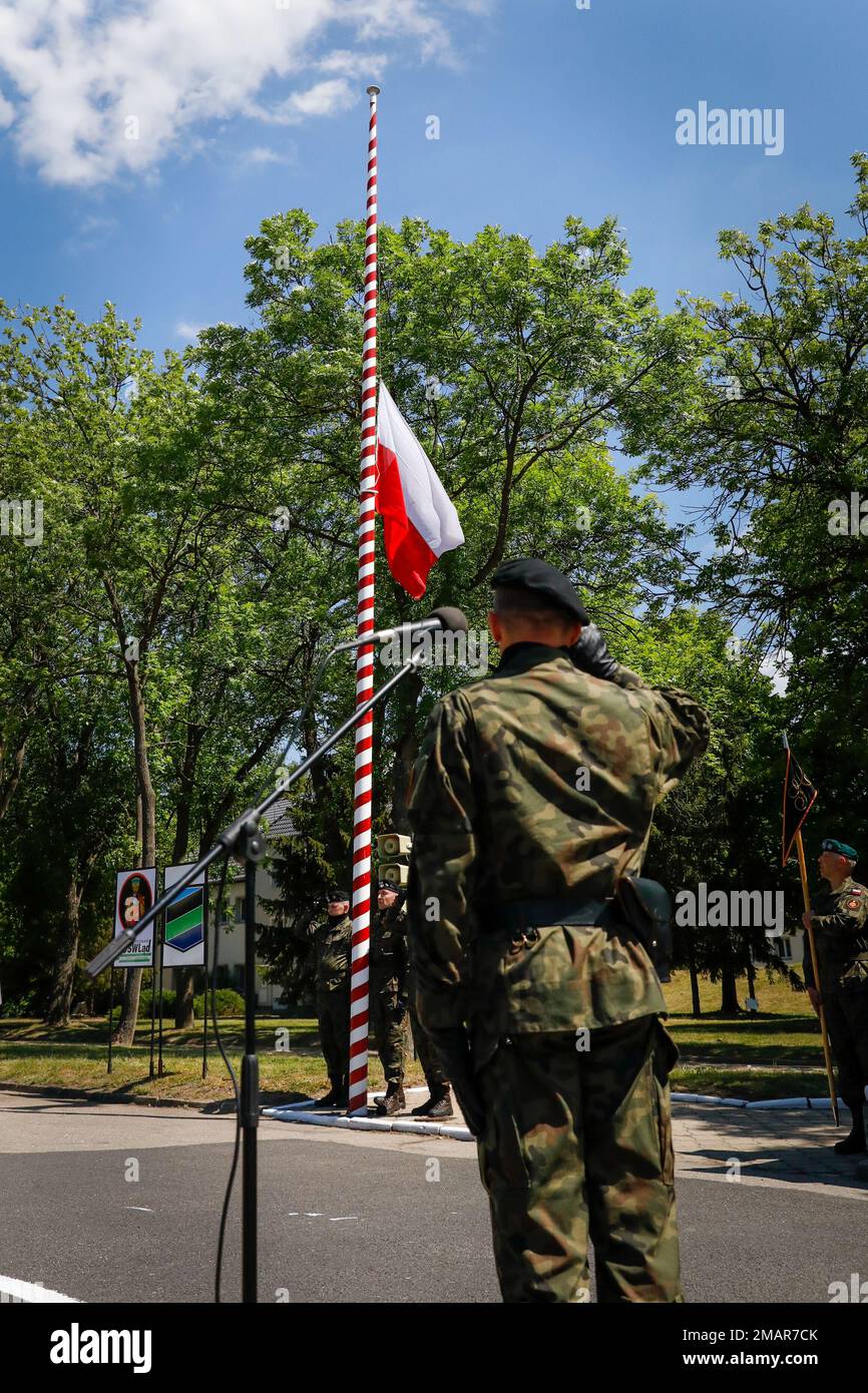 A Polish soldier salutes the flag of Poland as it is being raised ...