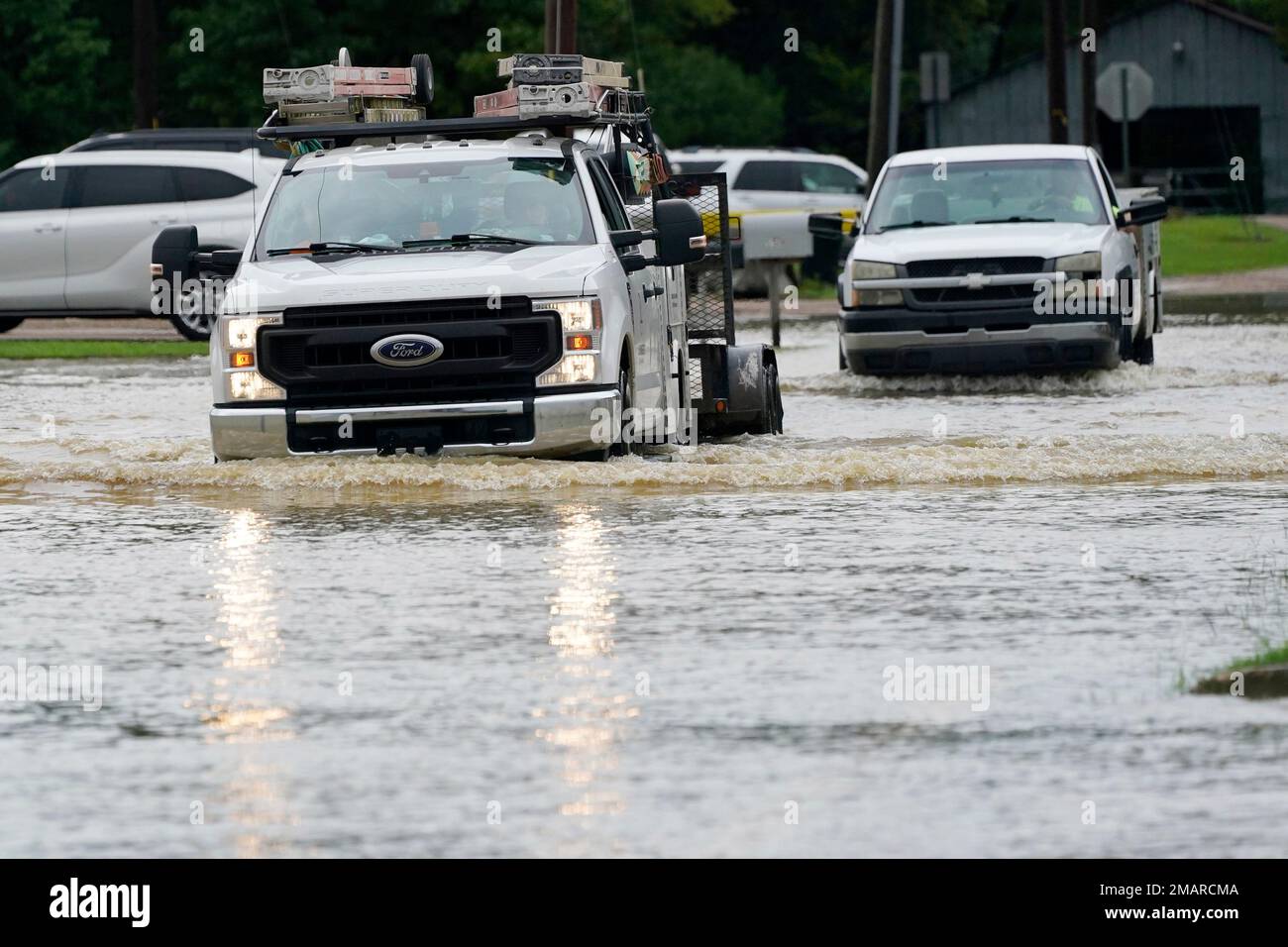 A couple of pickup trucks creep through flood waters in Richland, Miss ...