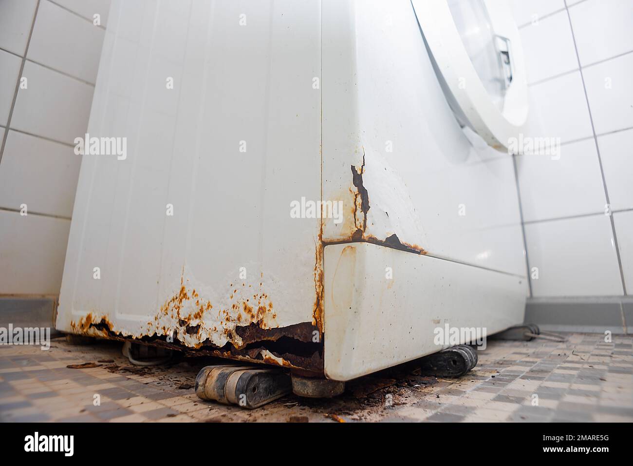 Rusty old washing machine in a bathroom - broken corner - wide angle ...
