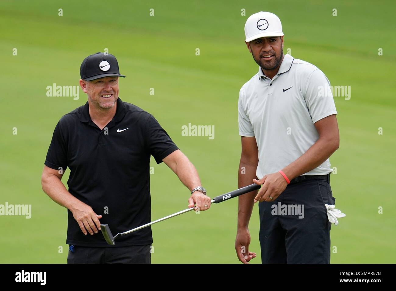 Tony Finau, right, hands his putter to his coach during a practice ...