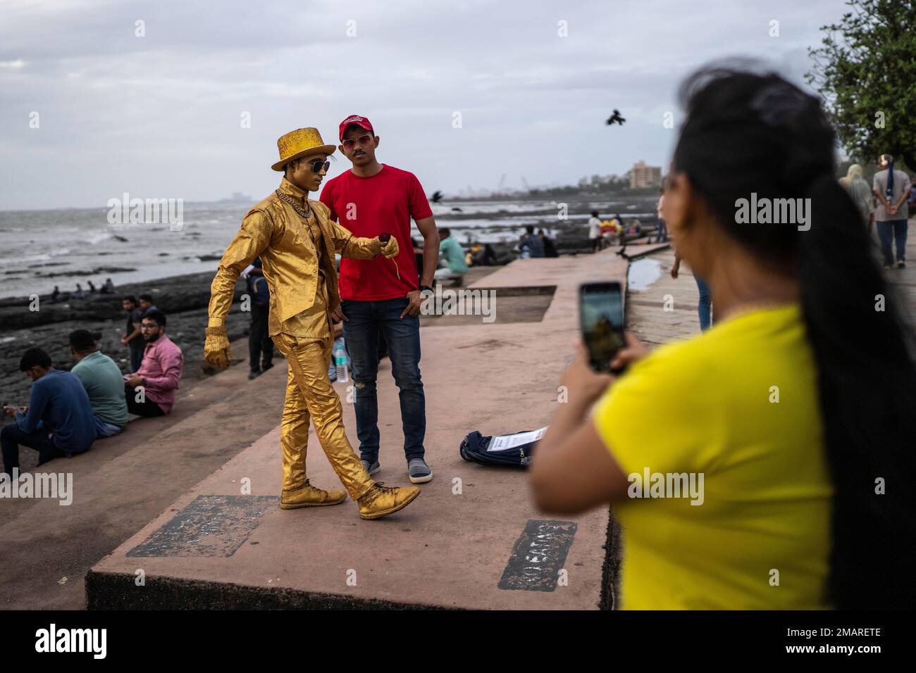 A man gets photographed with Mohammed taufeeq, a performance artist at a promenade in Mumbai ...