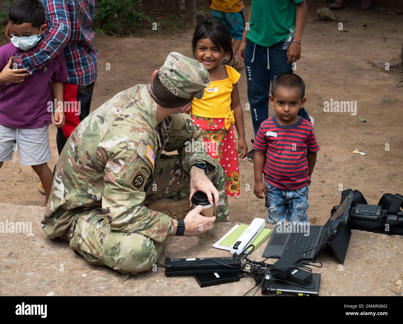 A U.S. Army soldier sets up a communications station while local ...
