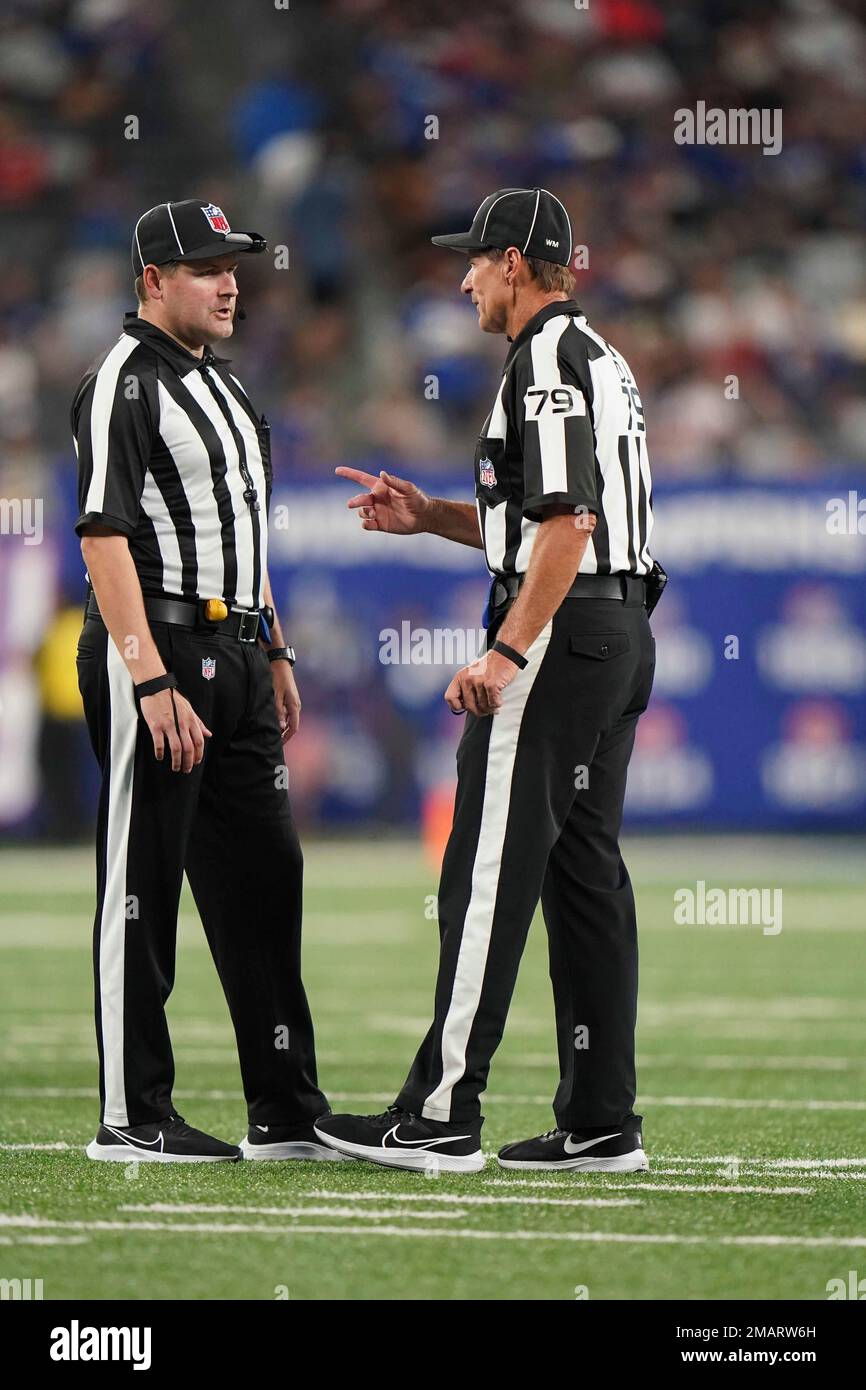 Line Judge Thomas Eaton (87) discusses a play with Down Judge Kent ...
