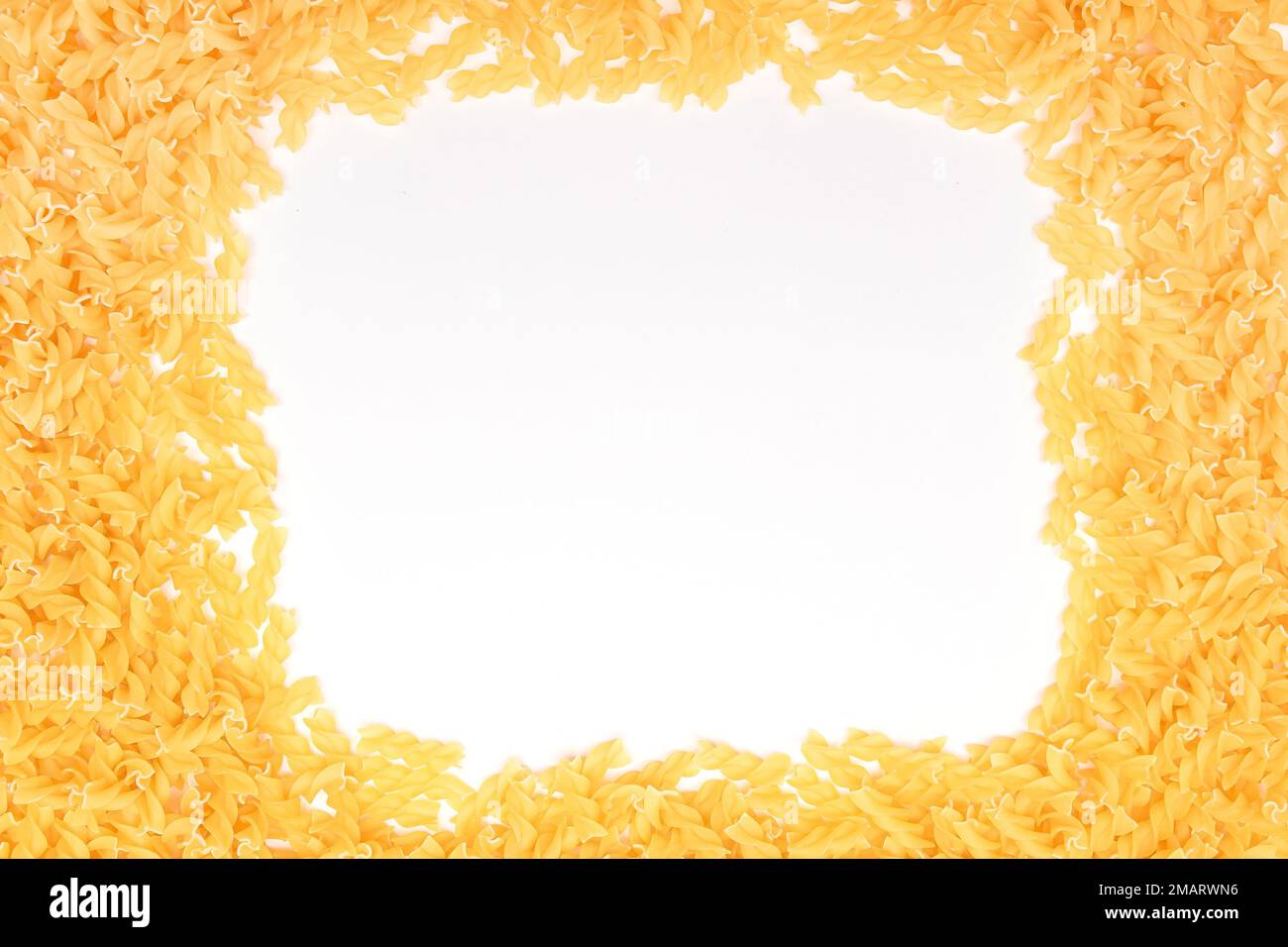 A Frame Made from Uncooked Fusilli Pasta Scattered on White Table ...