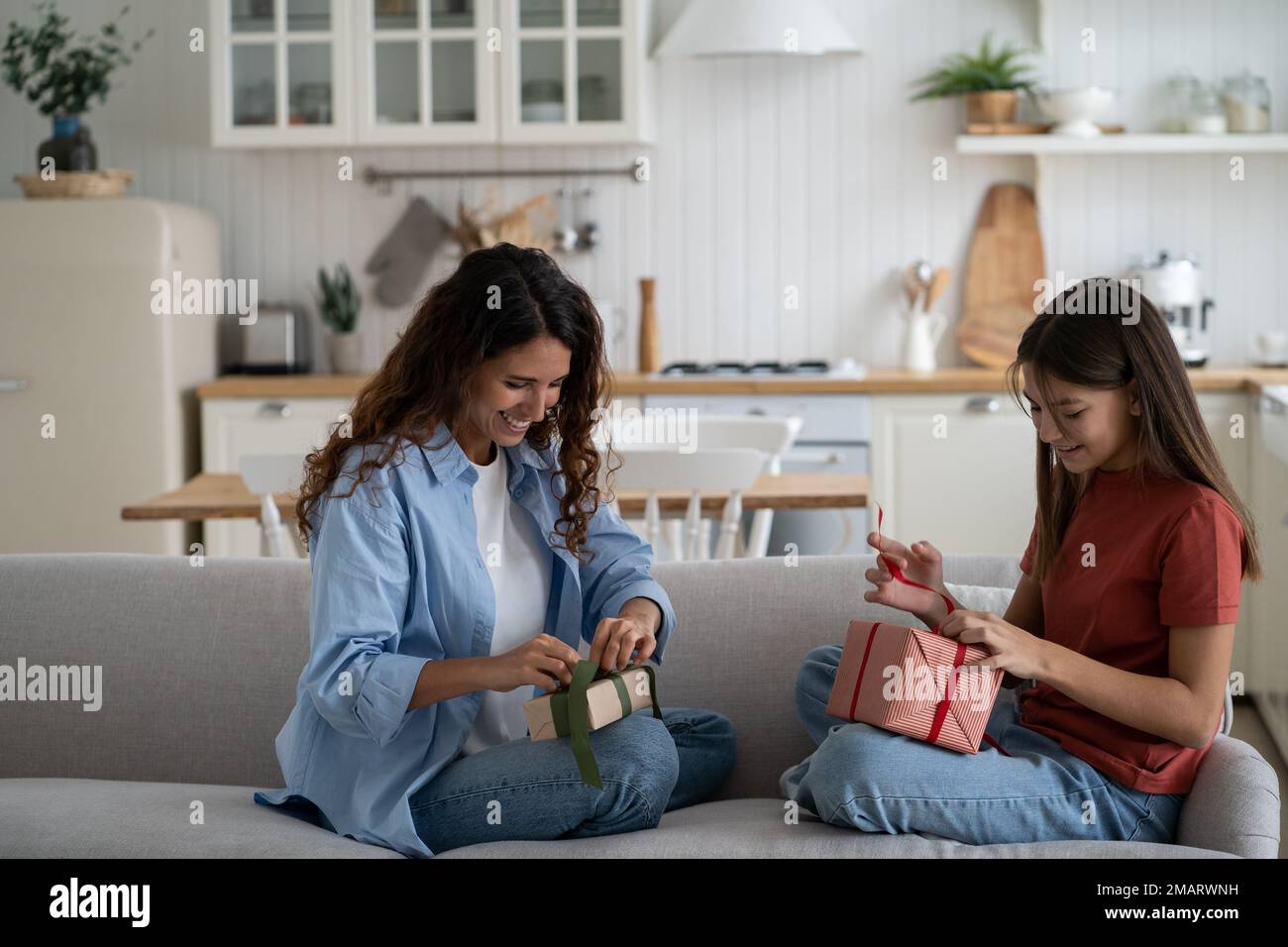 Smiling inspired woman and girl school age exchange gifts given on eve ...