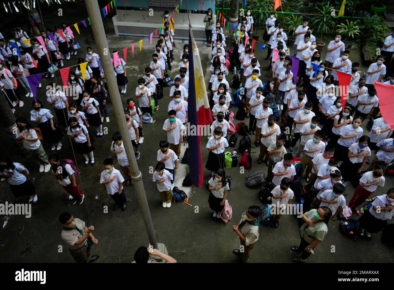 Students attend a flag raising ceremony during the opening of classes ...
