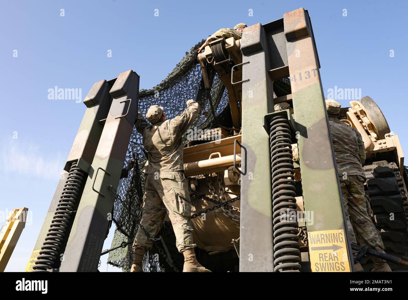 U.S. Army soldiers conceal an M1A3 Abrams Tank with camo netting before ...