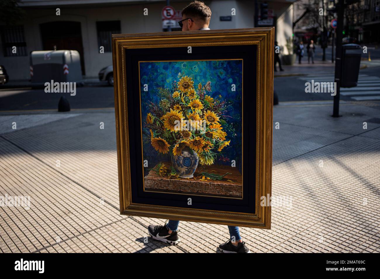 Michel Pfeiffer carries a painting titled "Girasoles" or sunflowers ...