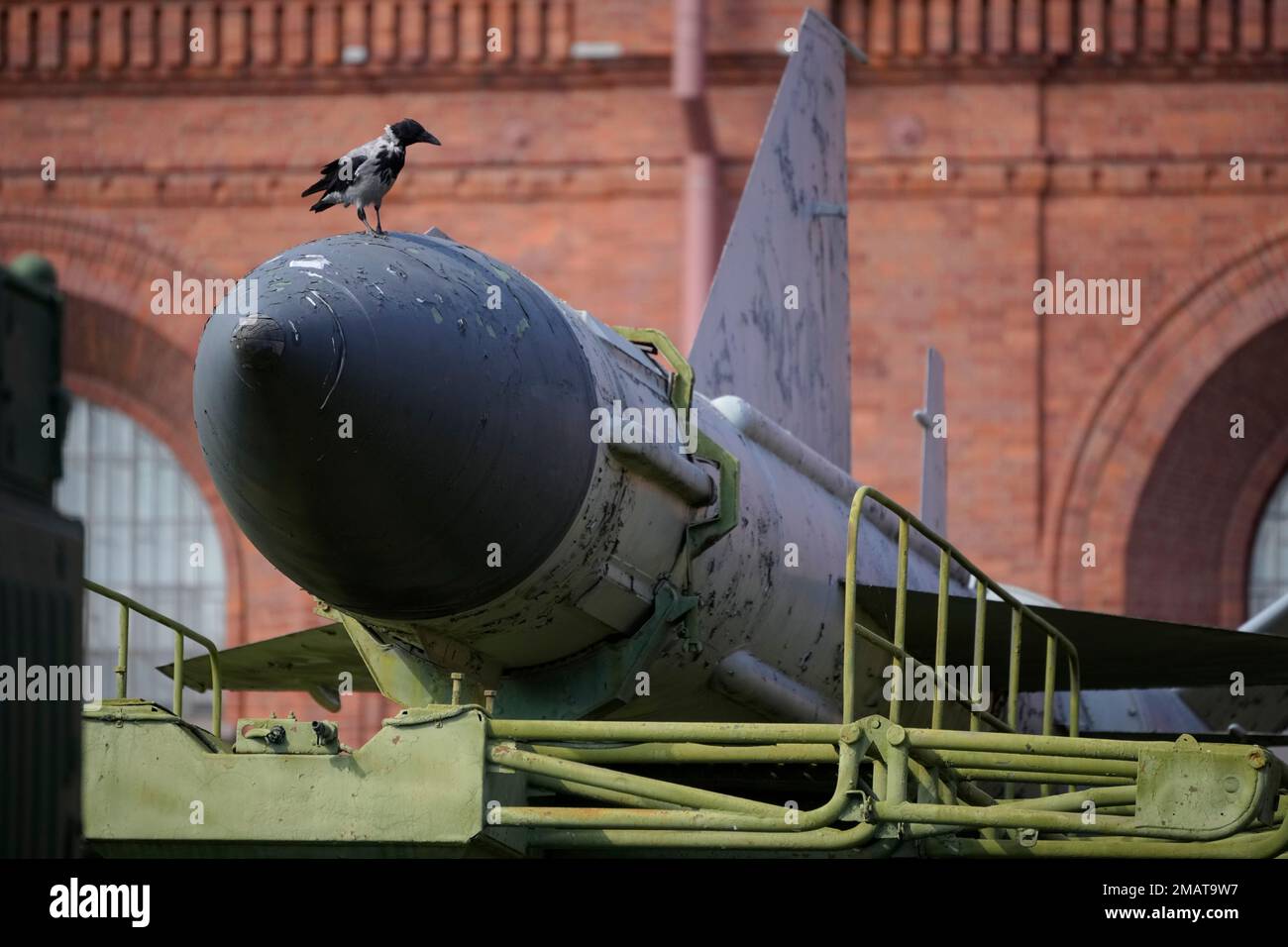 A crow sits on a Soviet anti-aircraft missile displayed in the yard of ...