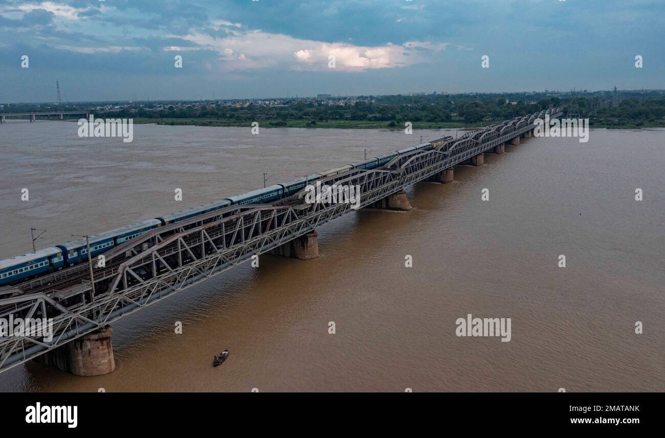 A train crosses Naini Bridge over the River Yamuna, swollen following ...