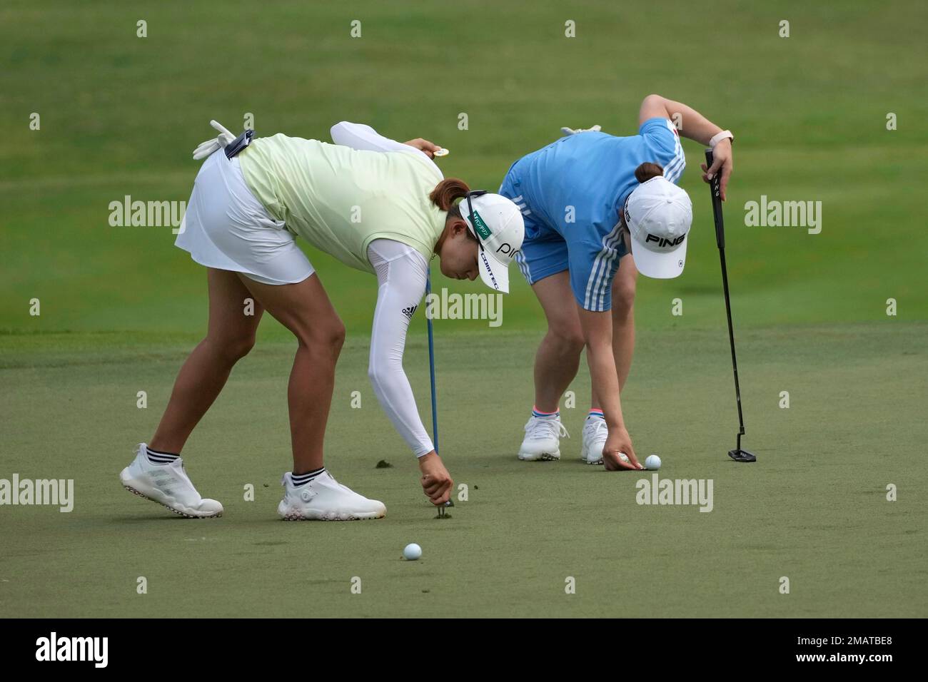 Japan's Hinako Shibuno, left, and her sister Kiriko mark their ball on the 10th green during ...