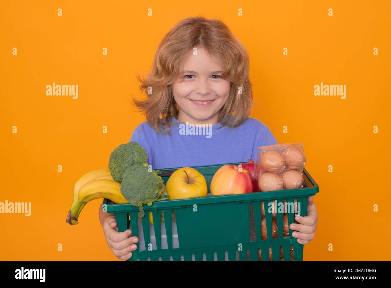 Portrait of child with shopping basket purchasing food in a grocery ...