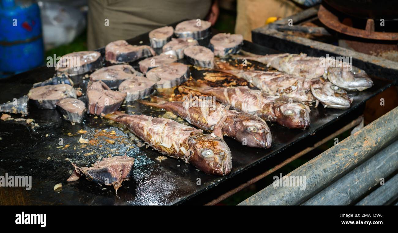 Fish and fish fillets grilling on hot iron surface top, Street sea ...