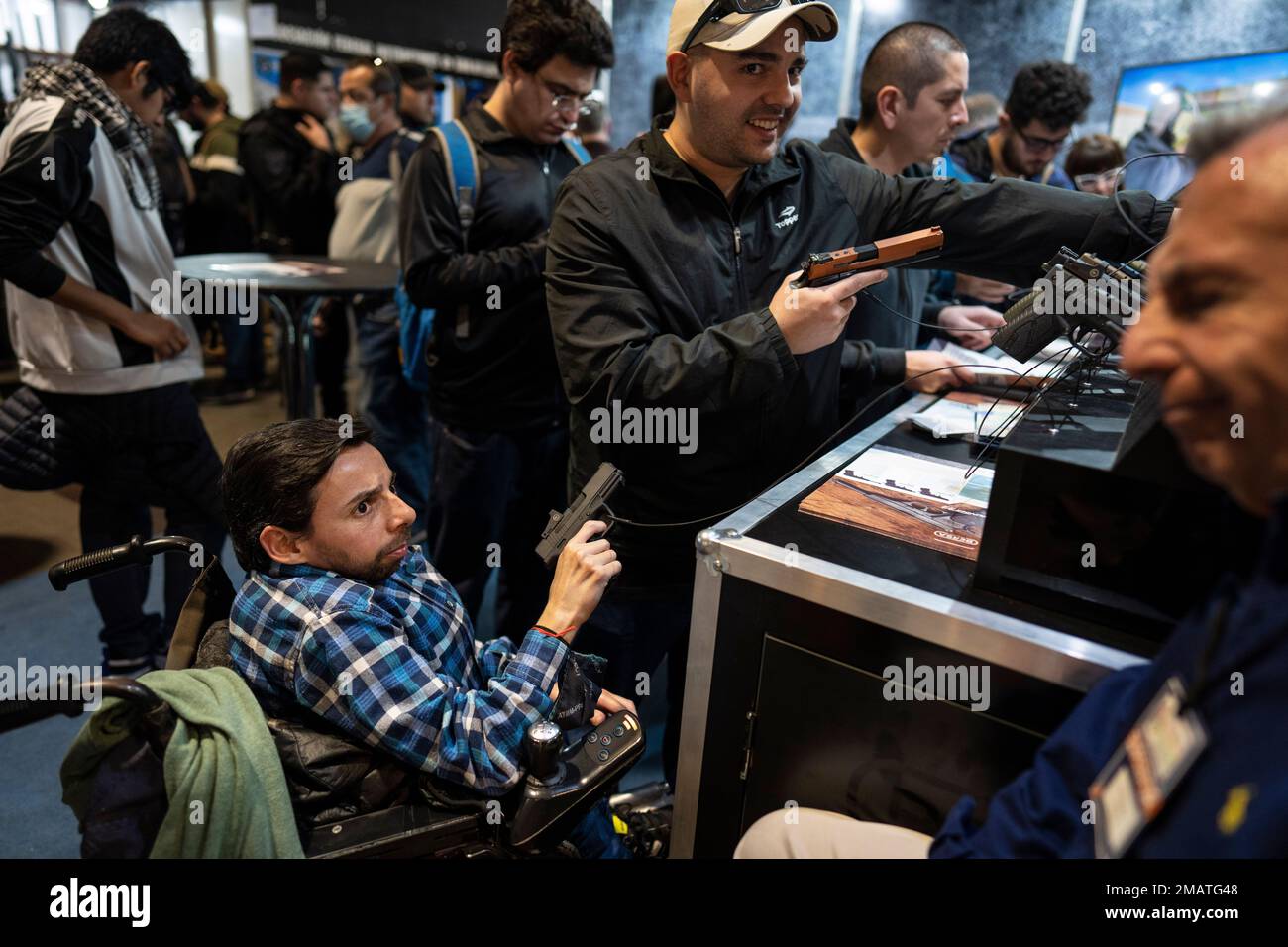 Visitors check out weapons on display at an armory stand during an ...