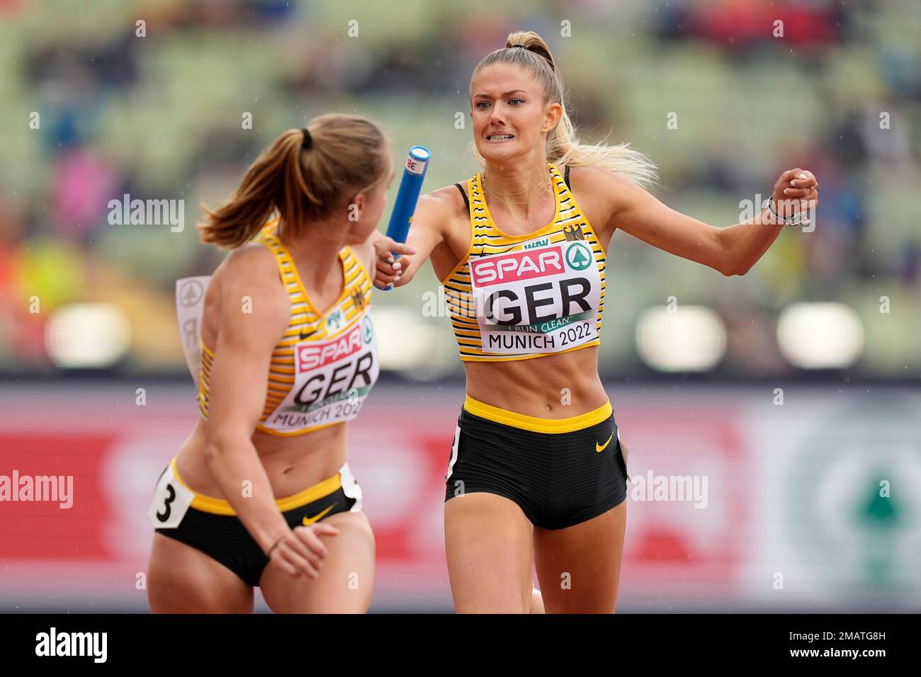 Alica Schmidt, of Germany, hands the baton in a Women's 4x400 meters ...