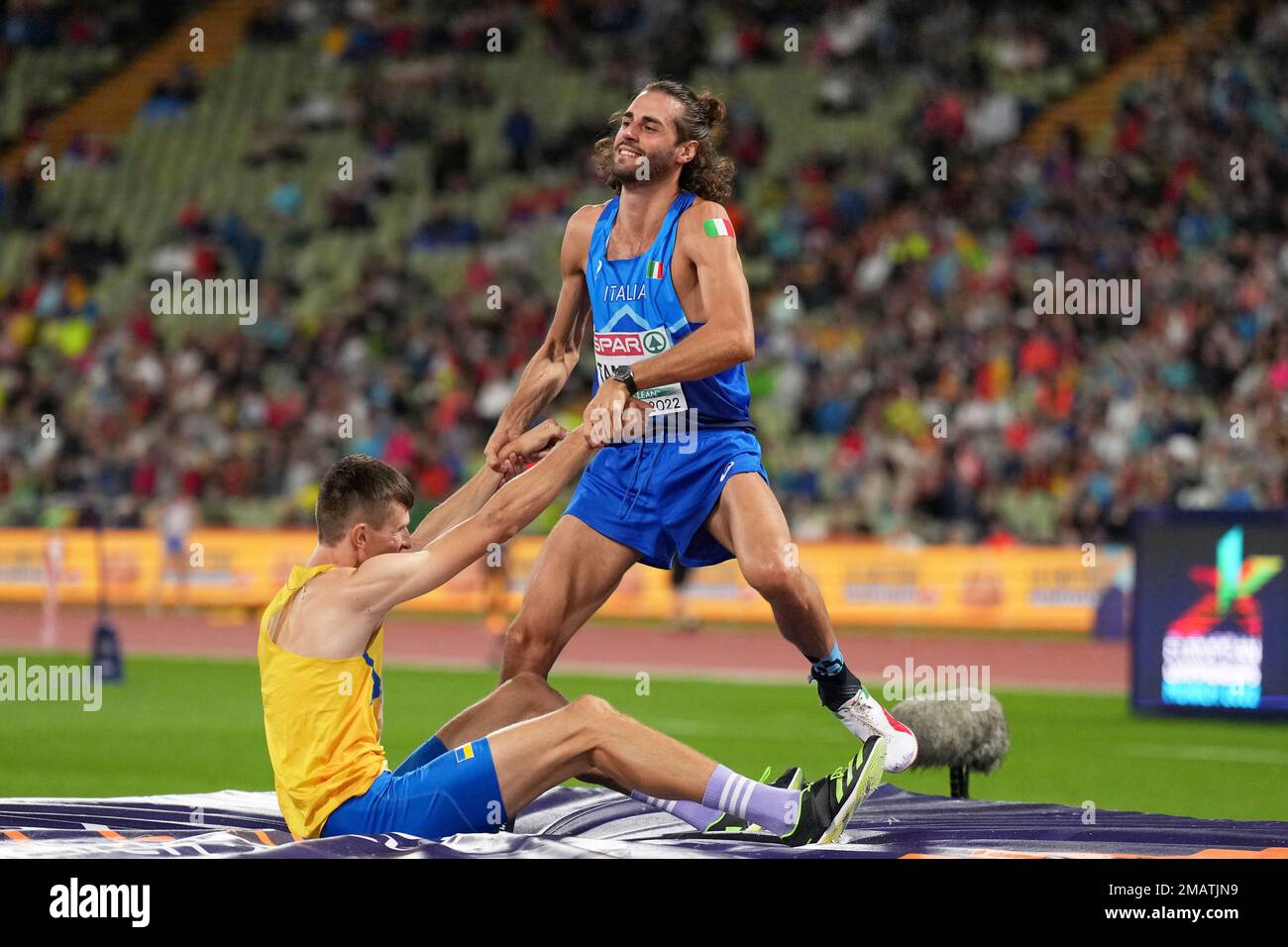 Gold medalist Gianmarco Tamberi, of Italy, picks up bronze medalist Andriy Protsenko, of Ukraine ...