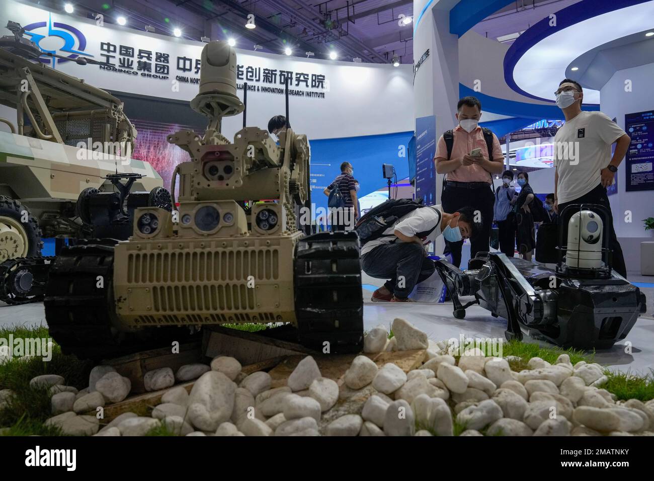 Visitors look at a Chinese-made robotic vehicles during the World Robot ...