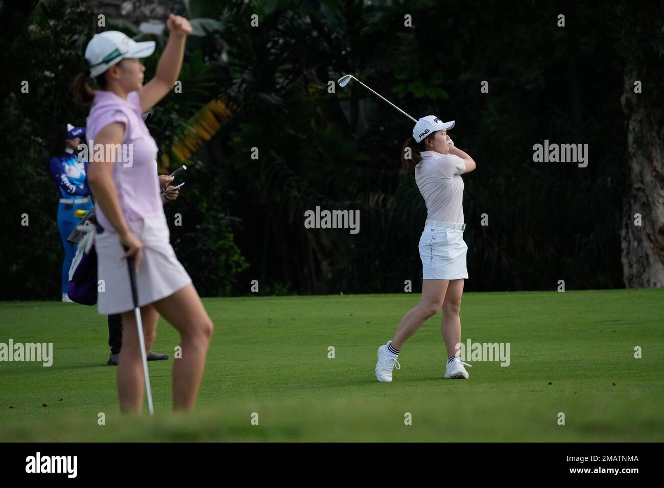Japan's Kiriko Shibuno, right, follows her shot on the first fairway as her sister Hinako, left ...