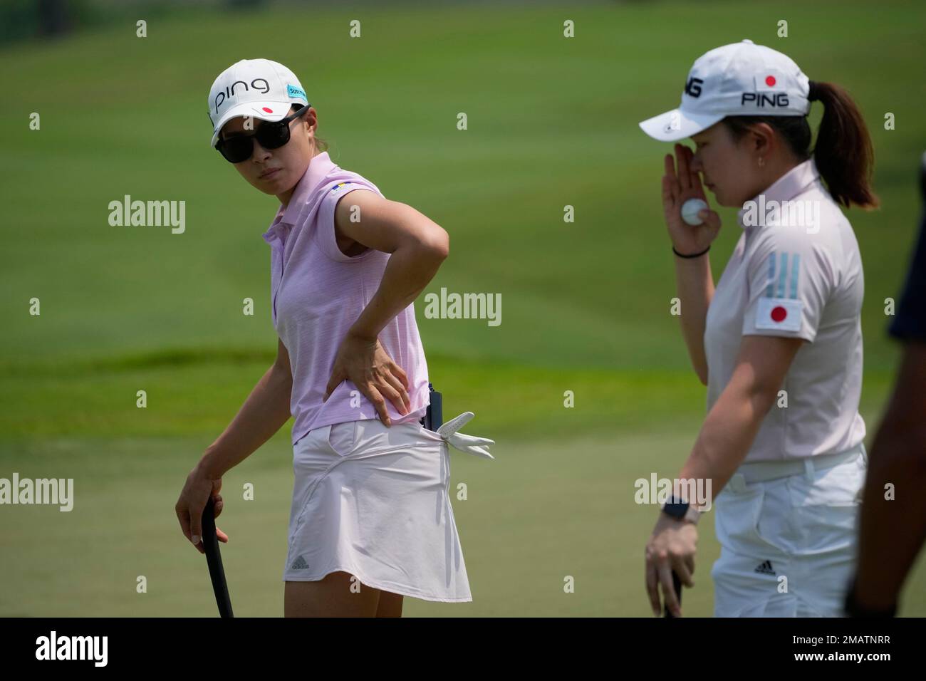 Japan's Hinako Shibuno, left, and her sister Kiriko react as they prepare to putt on the 7th ...