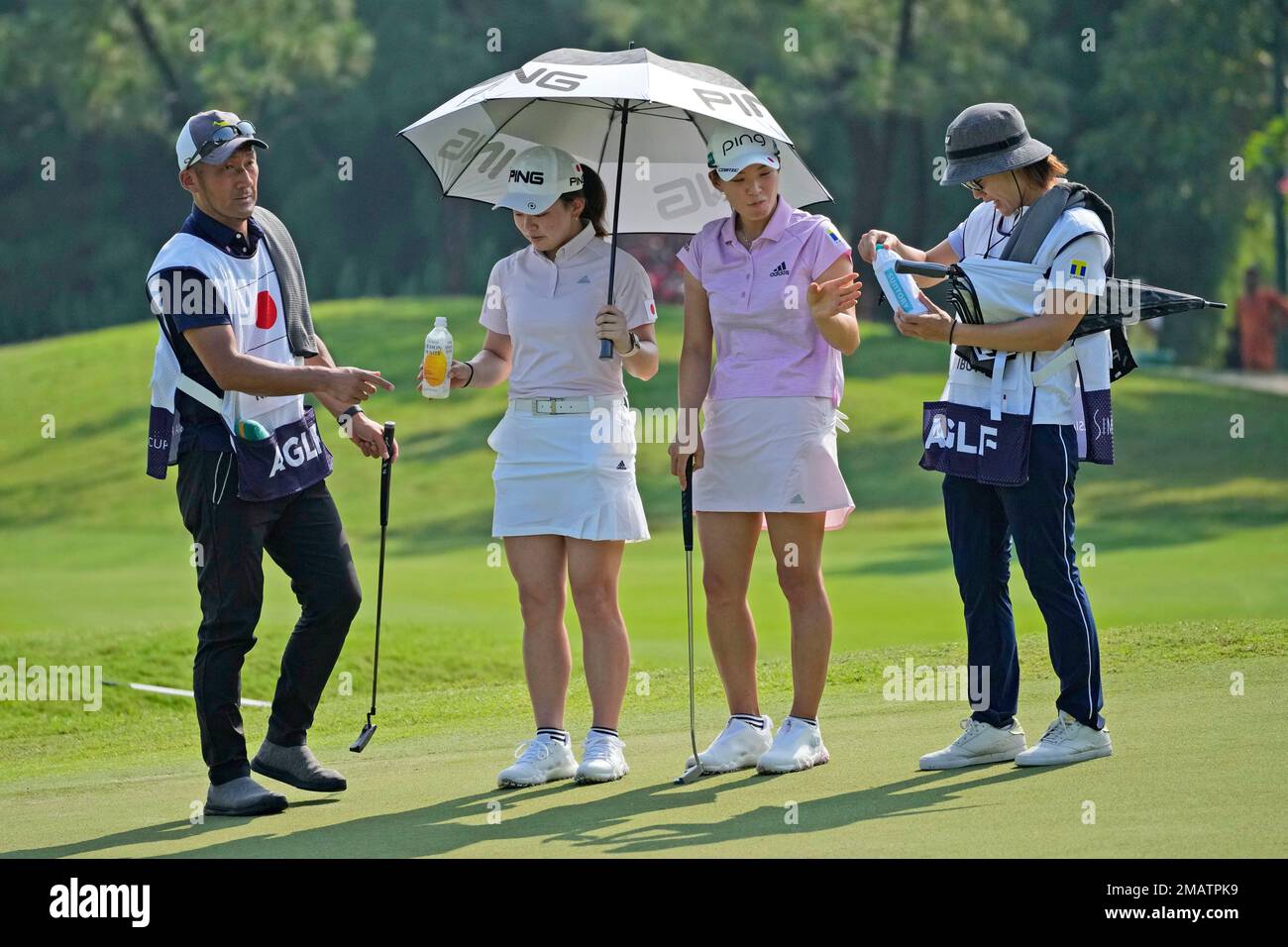 Japan's Hinako Shibuno, right, and her sister Kiriko take a drink on the fourth green during ...