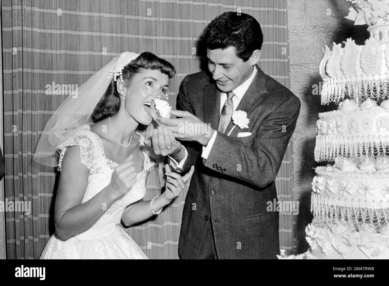 FILE - Singer Eddie Fisher feeds a piece of wedding cake to his bride, actress Debbie Reynolds ...