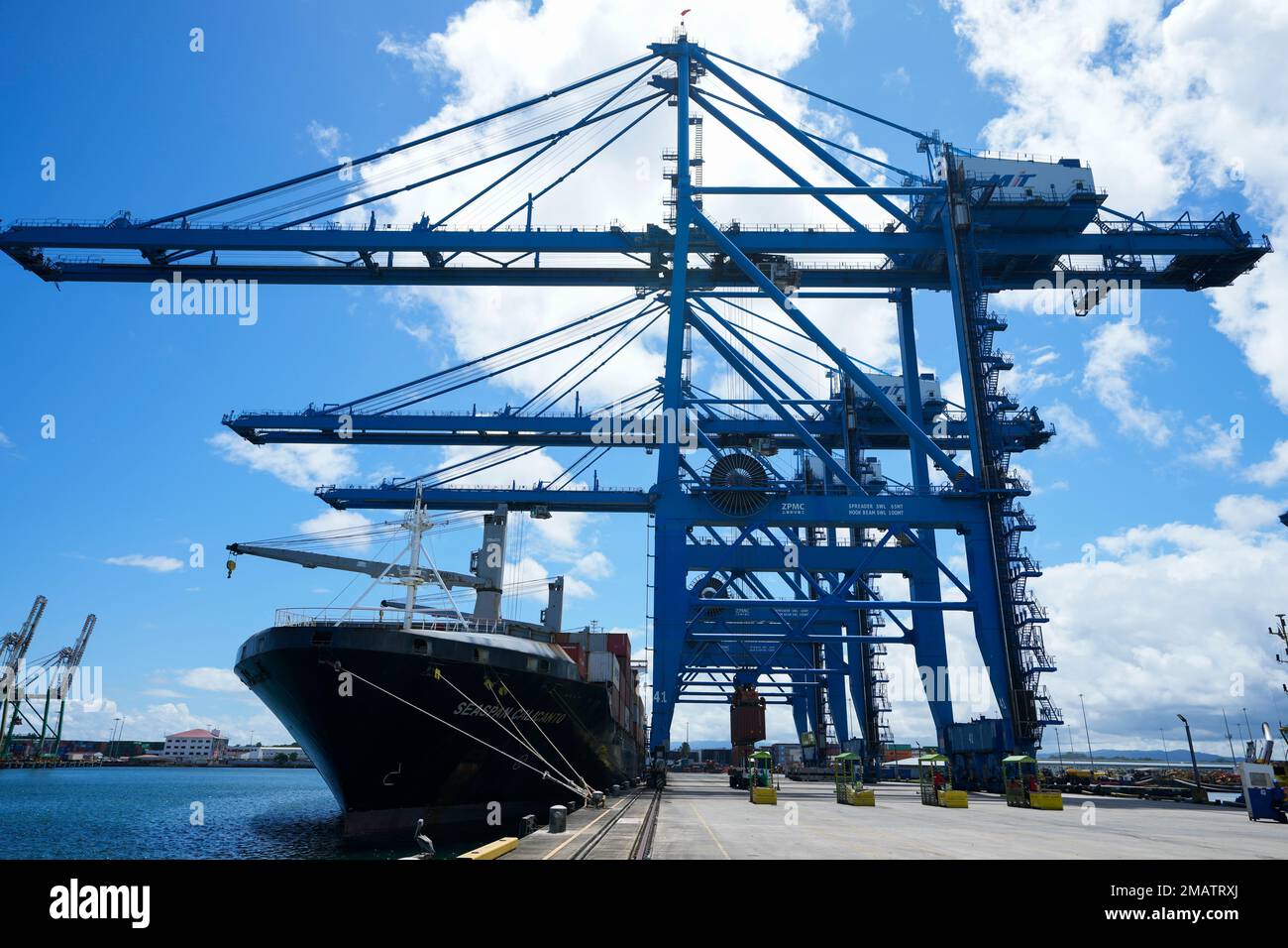 Cranes load and unload containers from a cargo ship at the Manzanillo ...