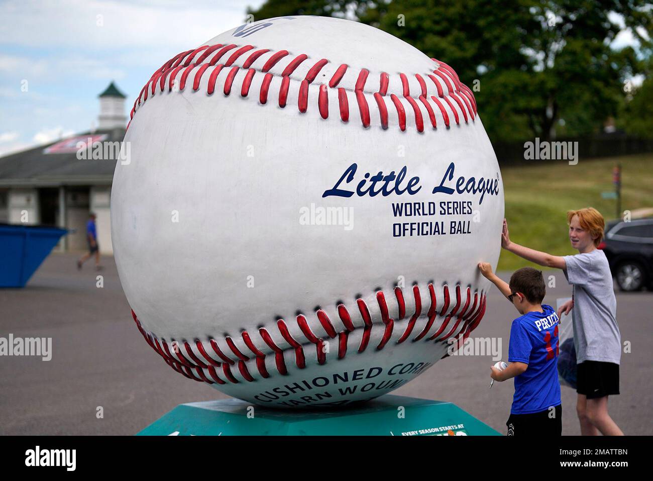 Little League baseball fans touch a giant baseball on display outside ...