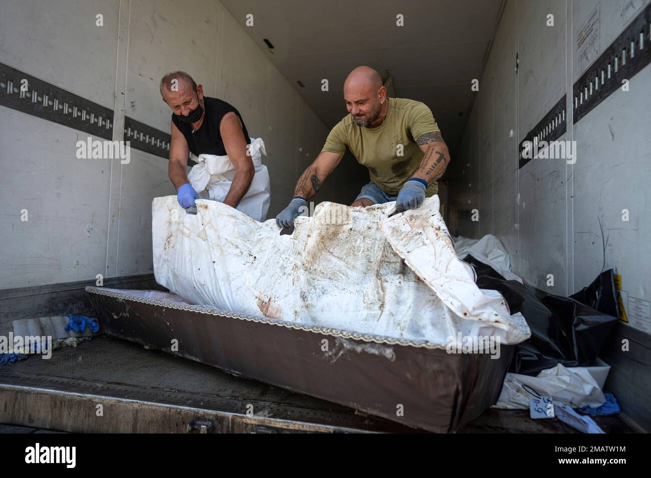 Funeral workers prepare a body of an unidentified civilian killed by ...