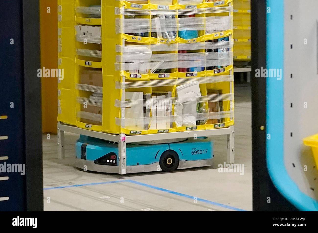 A stack of product loaded tubs is moved into a stow and picking kiosk ...