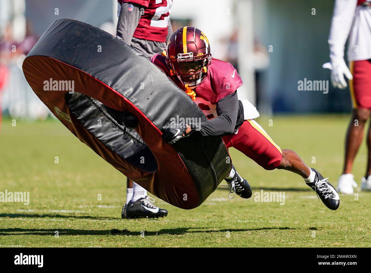 Washington Commanders defensive back Josh Drayden hits a tackling dummy ...