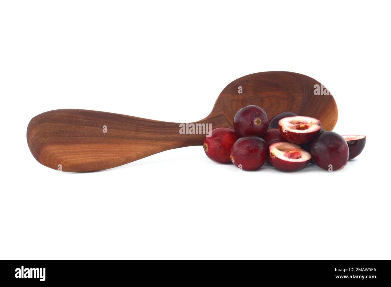 Fresh cranberries and cranberry berry cut in half in front of wooden ...