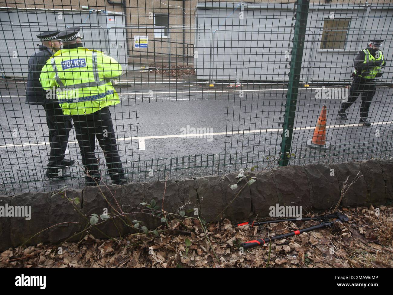 Police officers guard a hole that was snipped in the security fencing ...