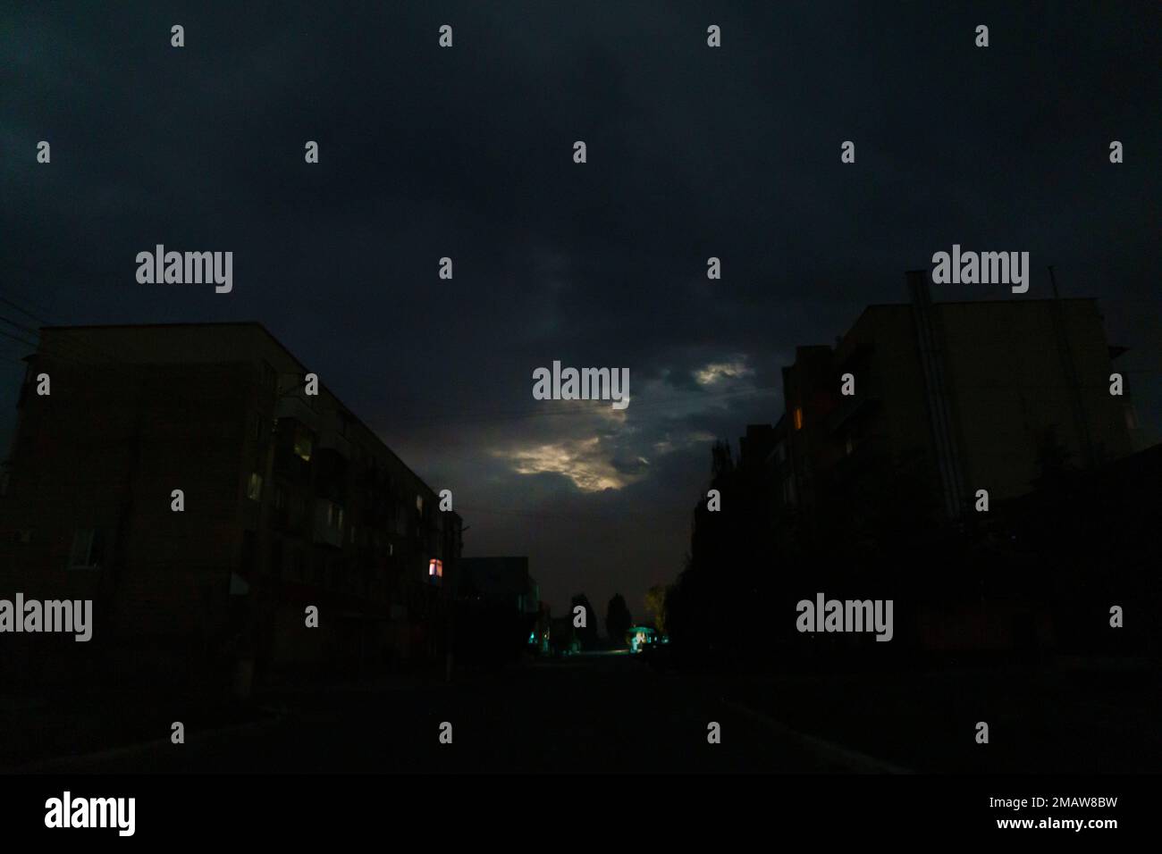 A street sits empty after a nightly curfew as the moon pokes through ...