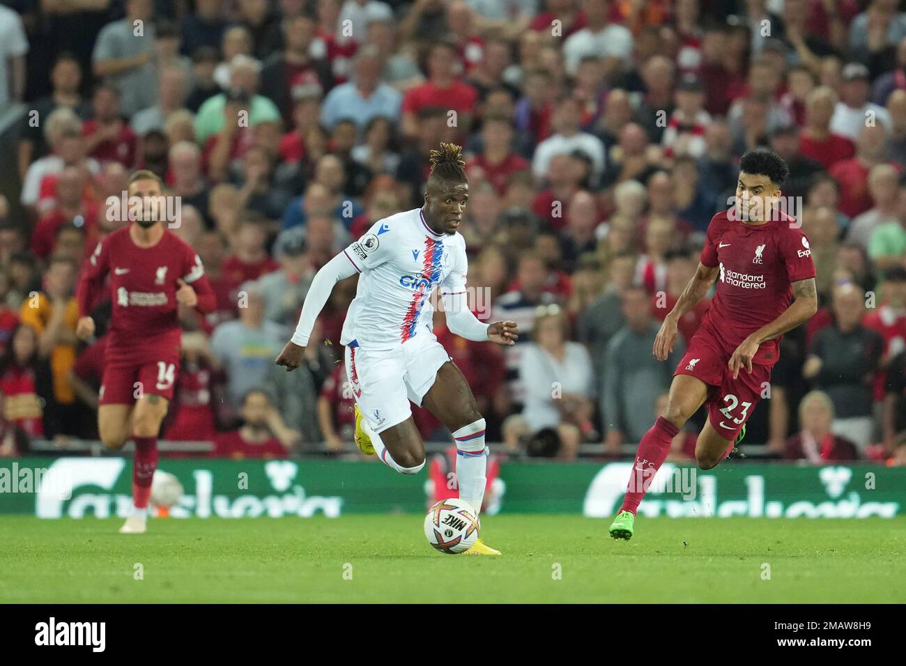 Crystal Palace's Wilfried Zaha runs with the app past Liverpool's Luis ...