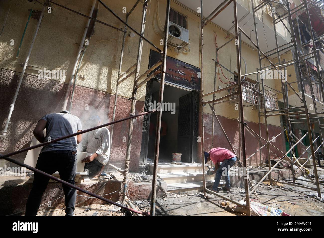 Workers restore the entrance of the Abu Sefein church a day after a ...