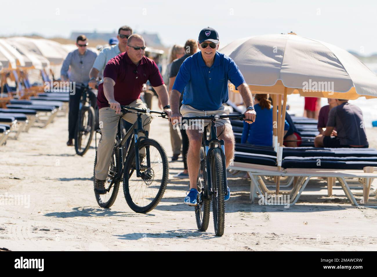 President Joe Biden rides a bicycle along the beach at Kiawah Island, S ...