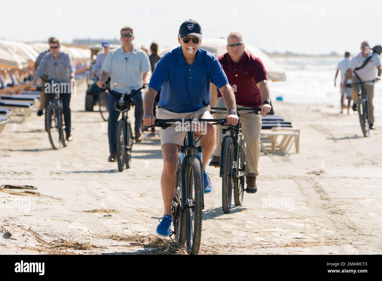 President Joe Biden rides a bicycle along the beach at Kiawah Island, S ...