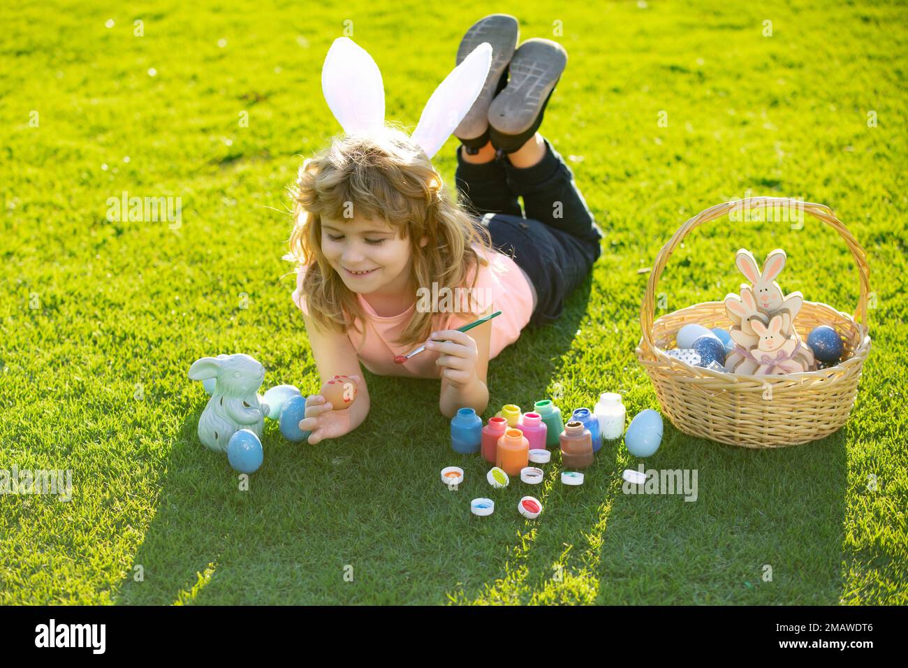 Kid laying on grass in park wit easter eggs. Children celebrating ...