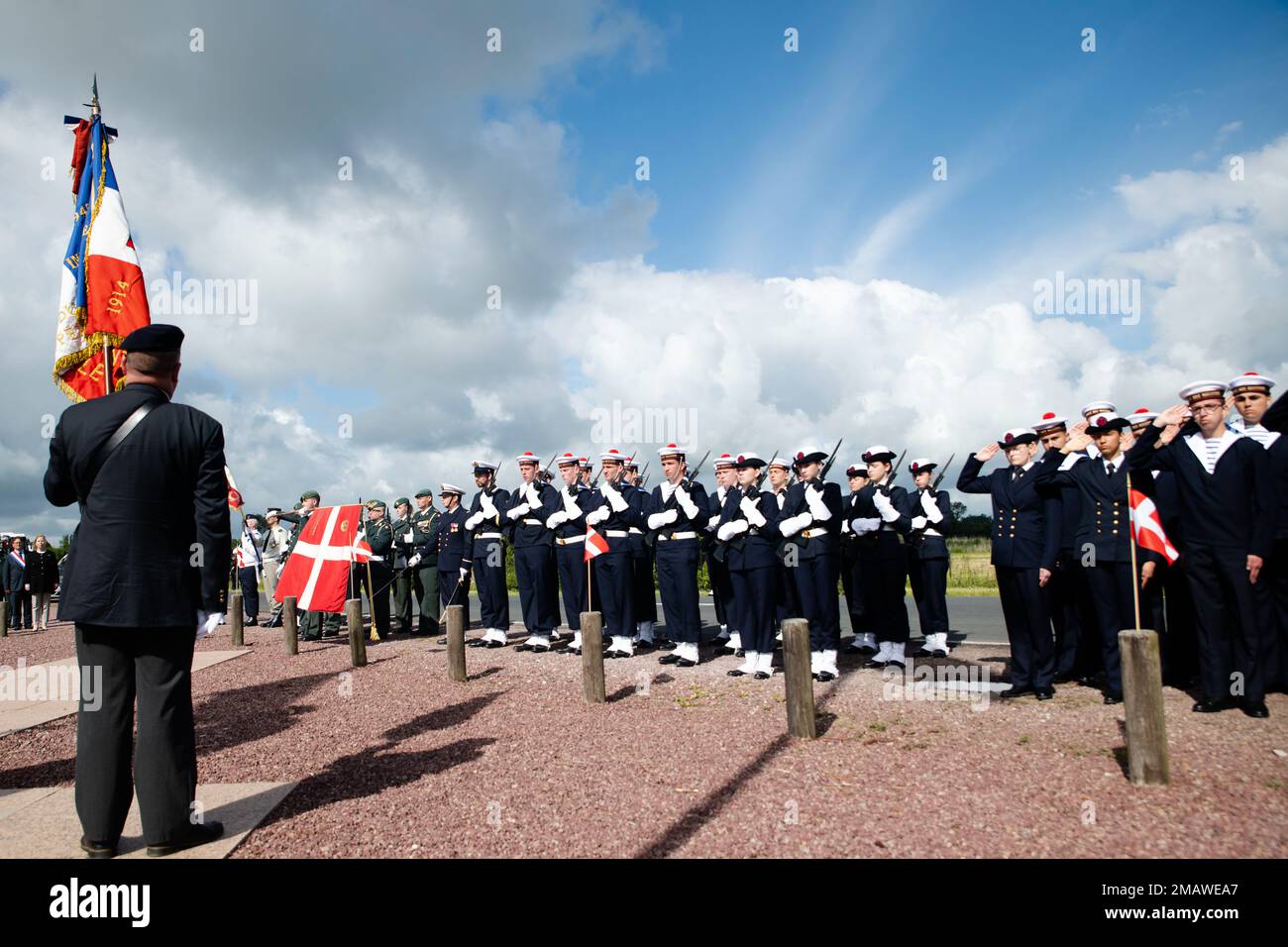 Danish and French military members stand at attention during a ceremony ...