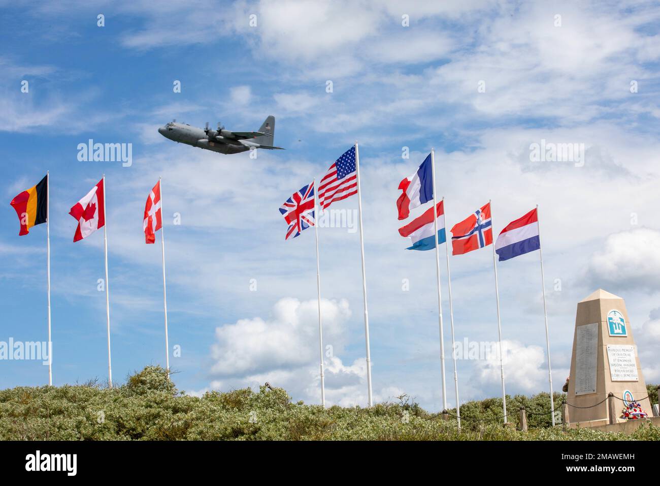 A C-130 Hercules flies over a D-Day ceremony at Utah Beach, France ...