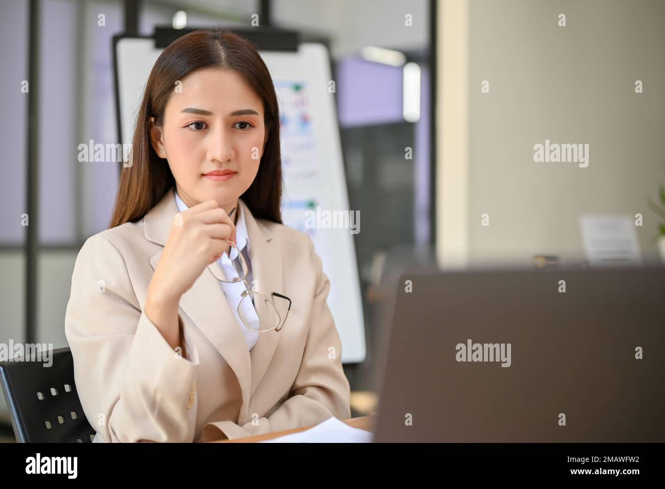 Focused and professional millennial Asian businesswoman or female boss ...