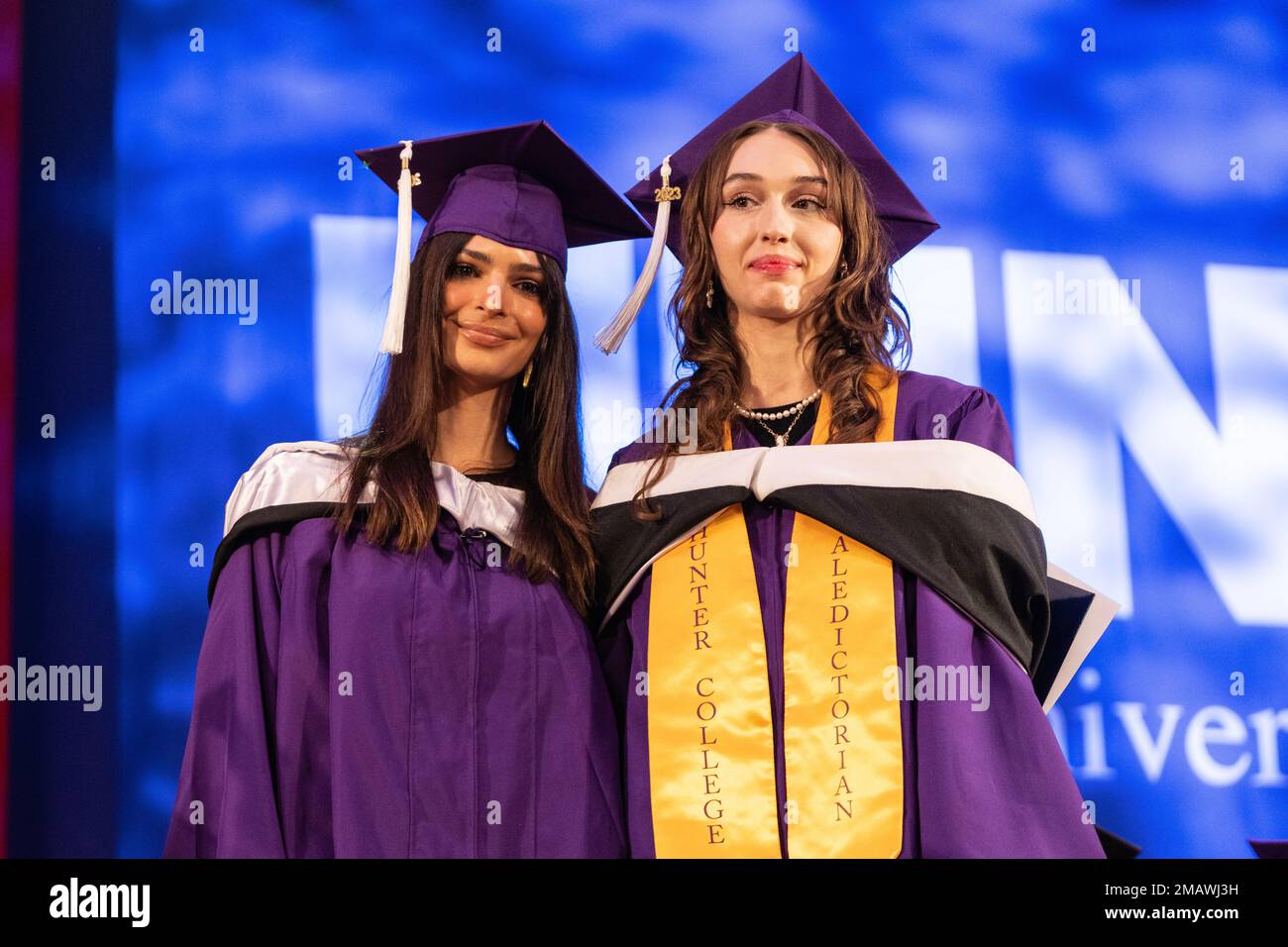 Emily Ratajkowski (L) poses on stage during winter commencement at ...