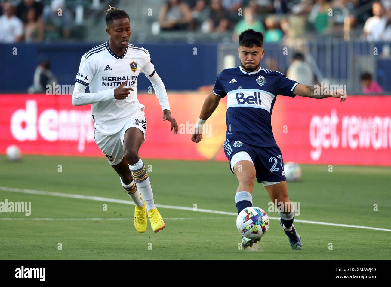 Vancouver Whitecaps midfielder Ryan Raposo, right, kicks the ball past ...