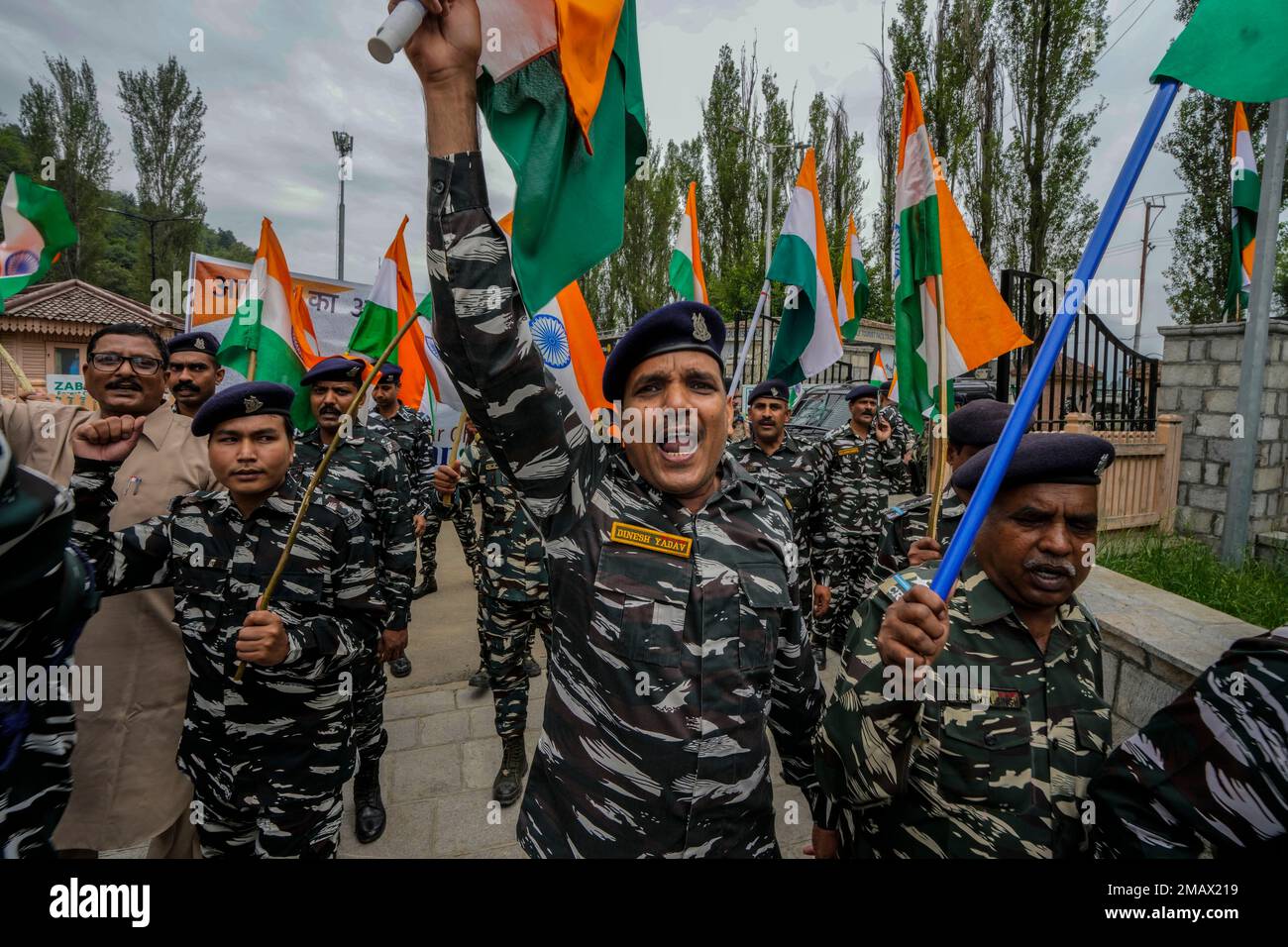 Indian paramilitary officers hold national flags and shout slogans as ...